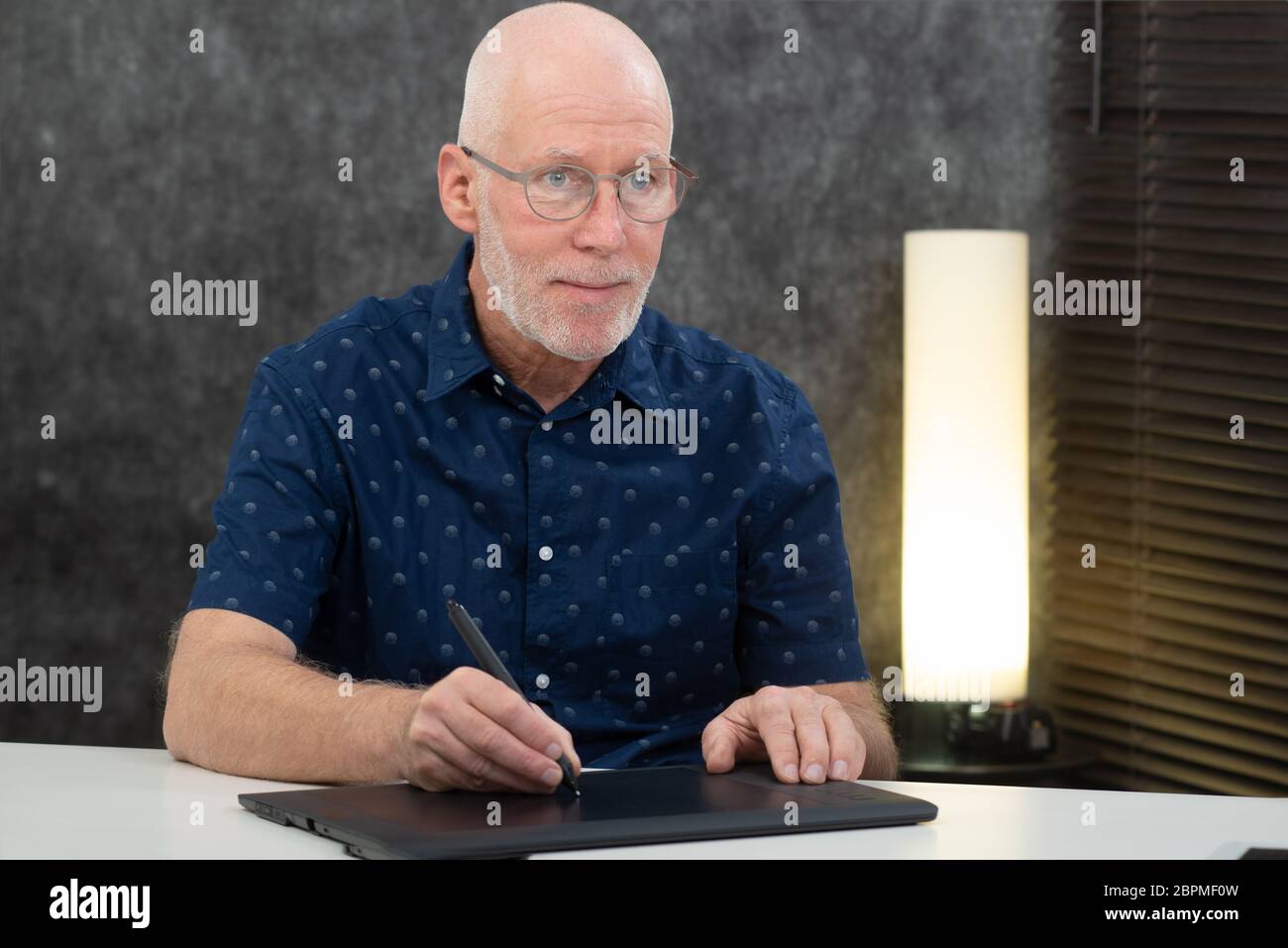 Mature graphic designer using digitized pen Stock Photo - Alamy