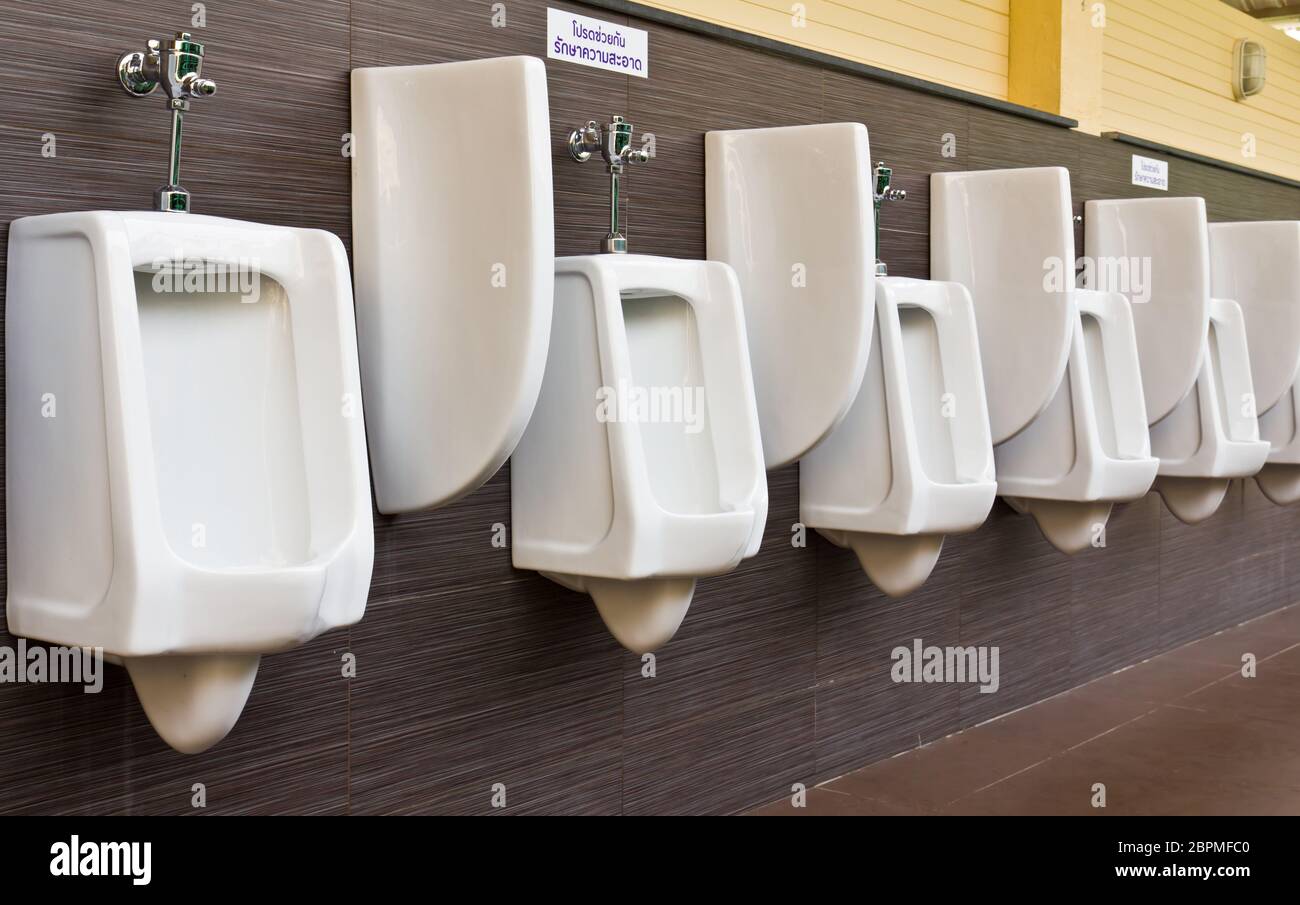 Row of white porcelain urinals in public toilets Stock Photo - Alamy