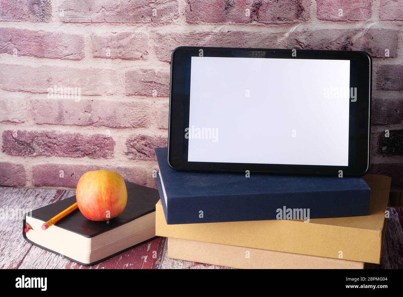 digital tablet with white screen on stack of books Stock Photo - Alamy