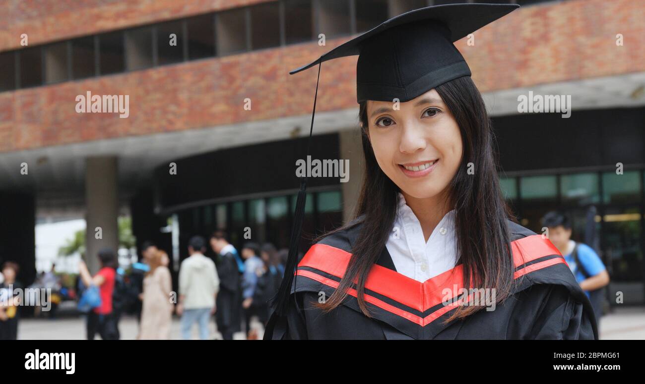 Asian woman wearing graduation gown Stock Photo - Alamy