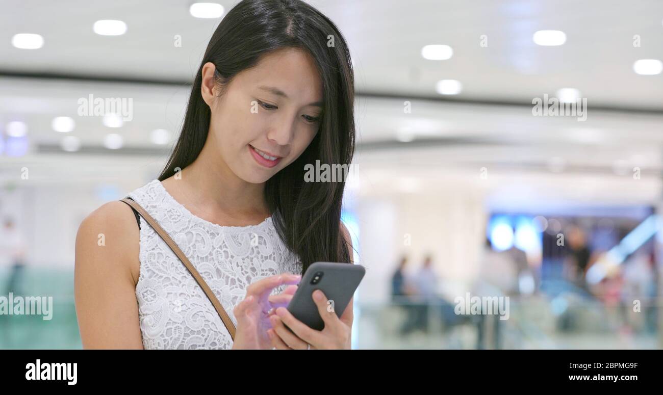 Woman use of mobile phone inside shopping mall Stock Photo - Alamy