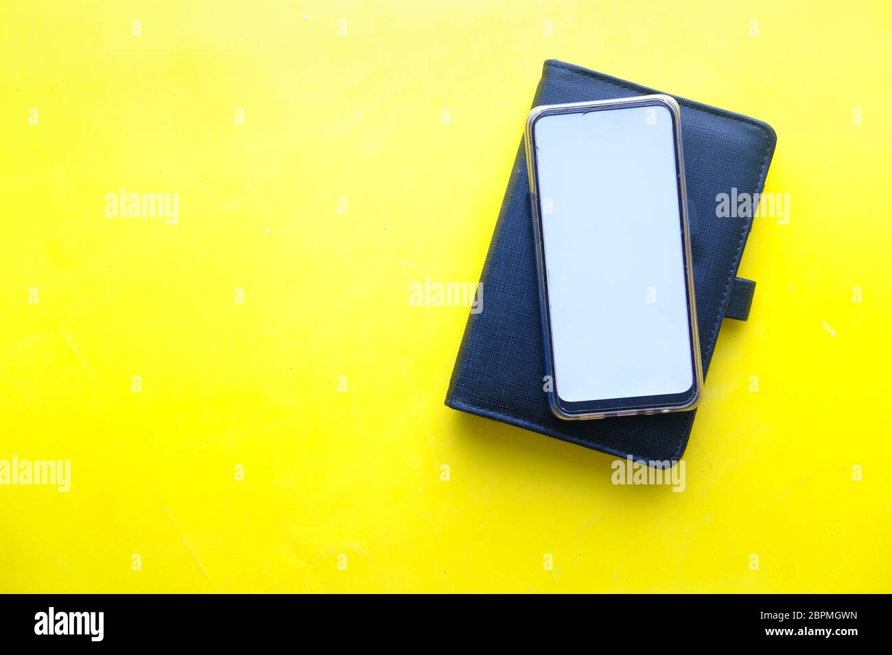 smart phone with empty screen and notepad on yellow background Stock ...
