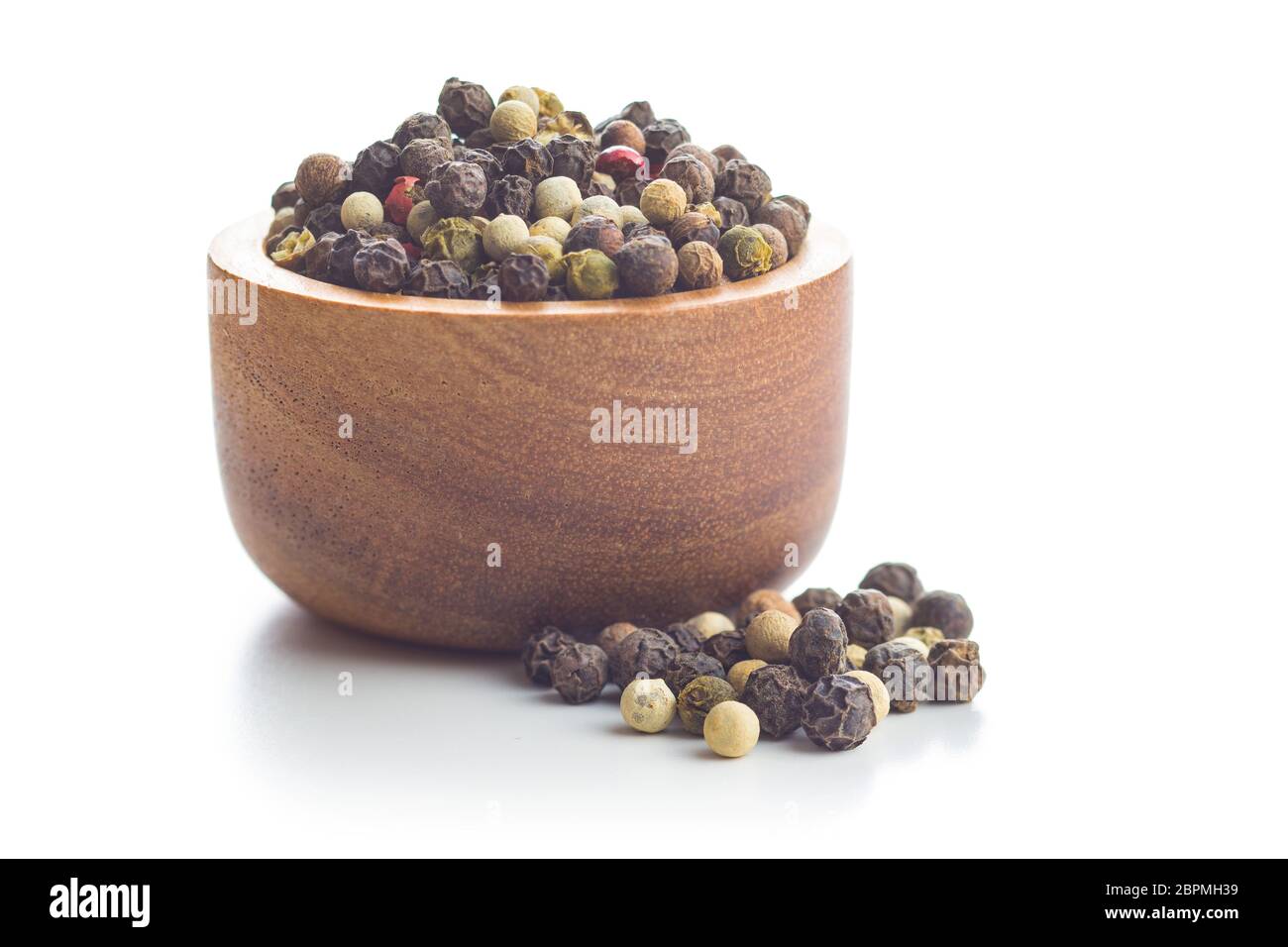 Different types of dried peppercorn in bowl isolated on white ...
