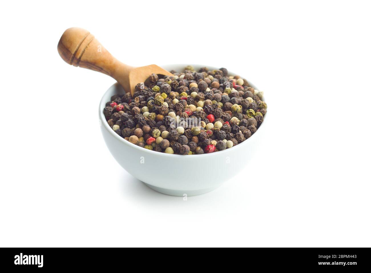 Different types of dried peppercorn in bowl isolated on white ...