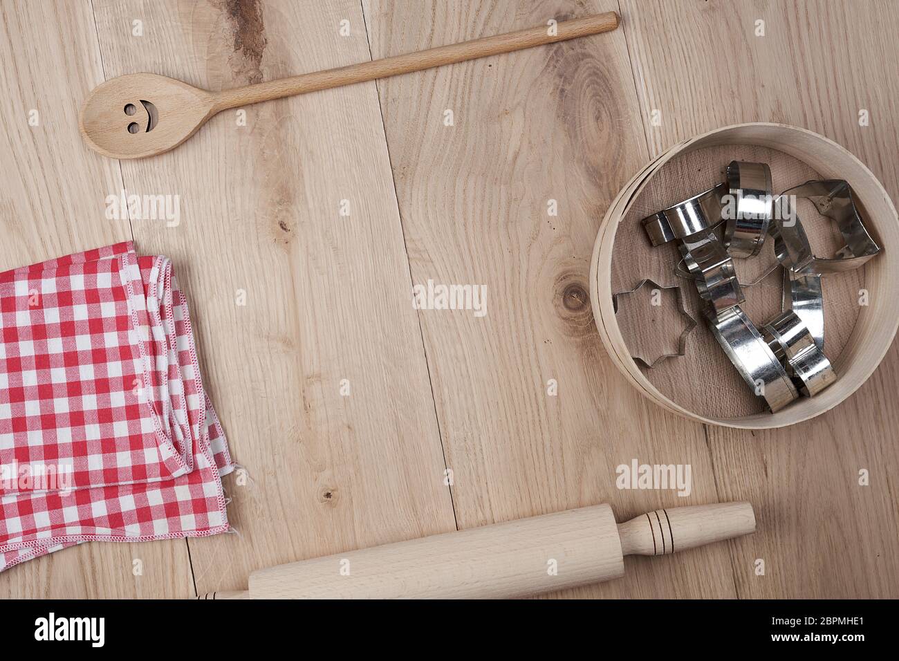 round wooden sieve with baking molds and rolling pin, top view, copy ...