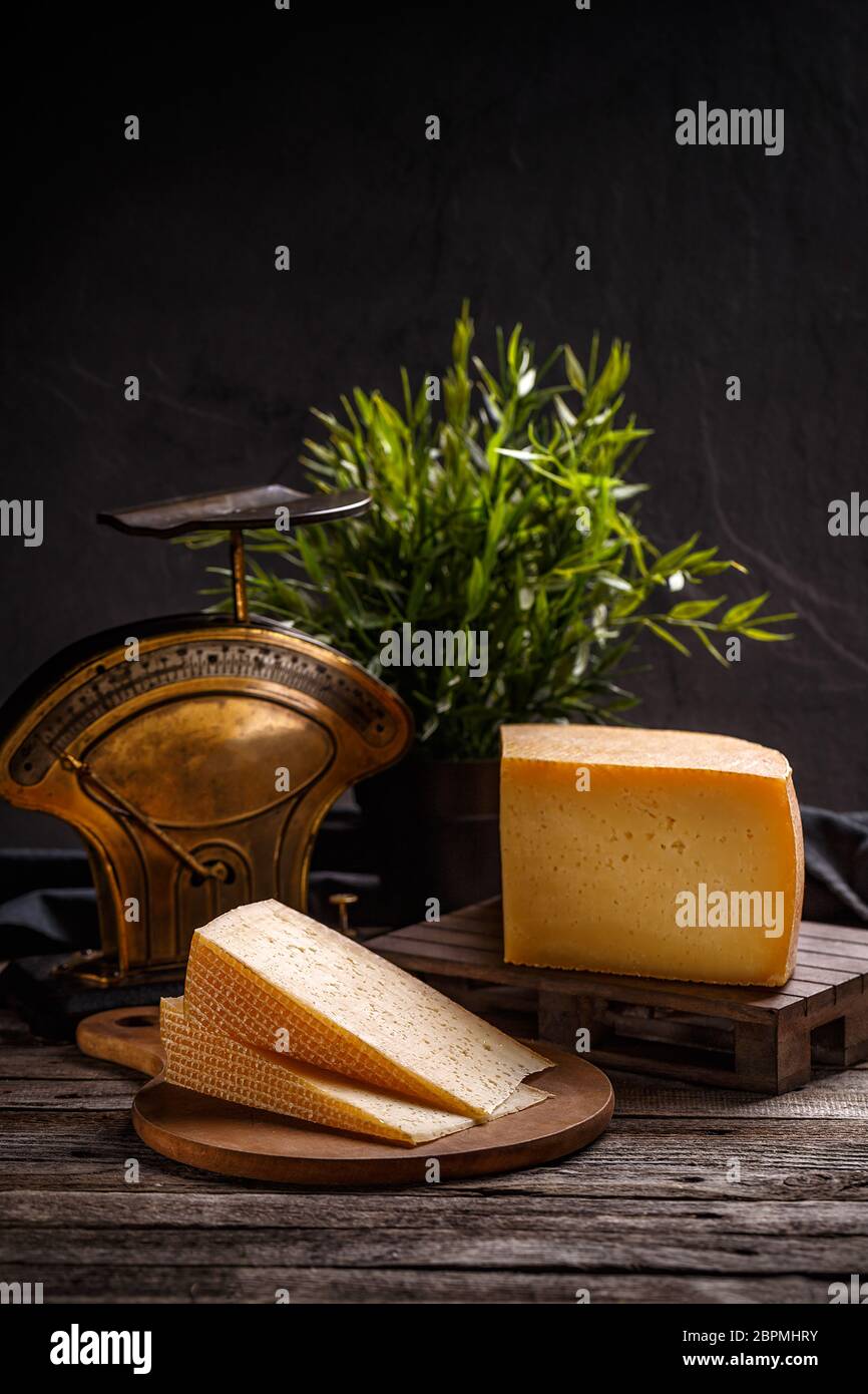 Mature cheese composition with vintage scale on wooden background Stock ...