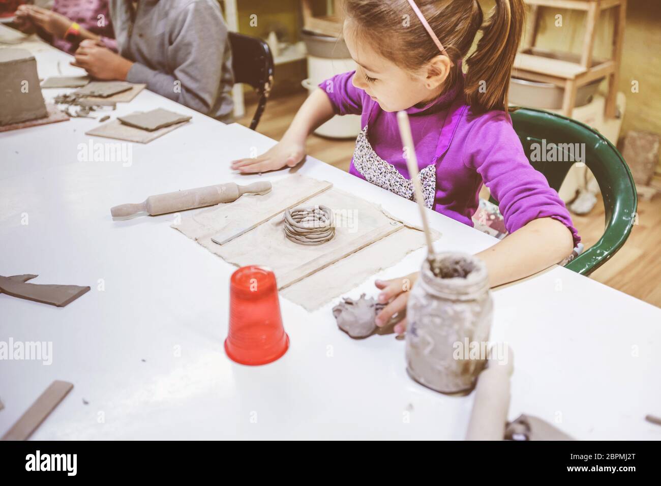 Child pottery workshop, little girl working with clay, creative ...
