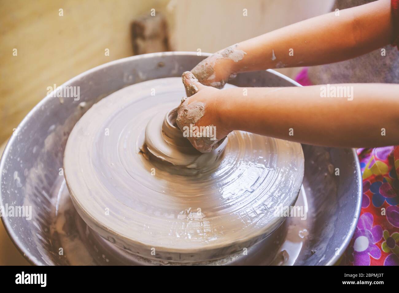 Hands of young artist shaping clay on pottery wheel- Creative Education ...