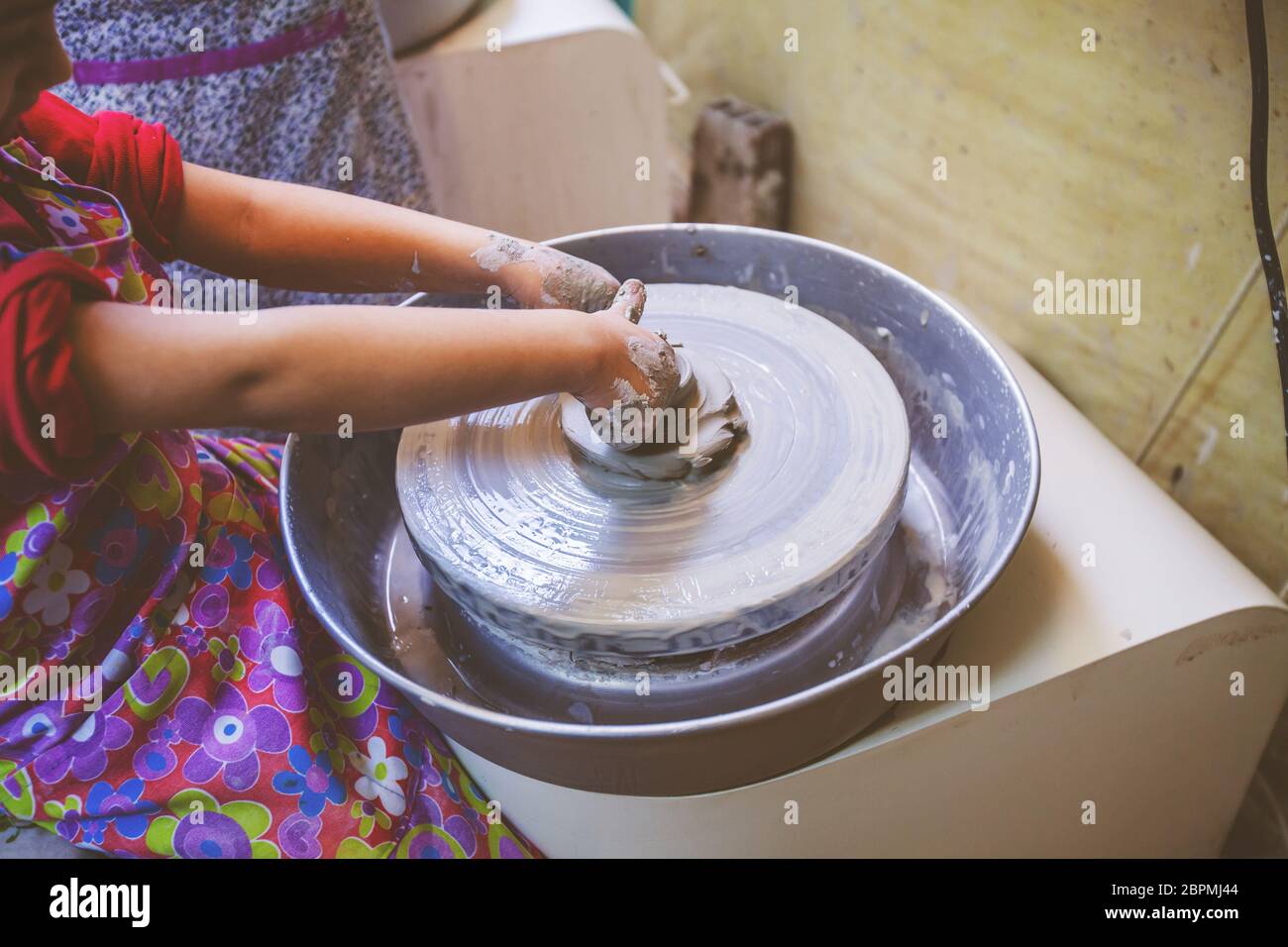 Hands of young artist shaping clay on pottery wheel- Creative Education ...