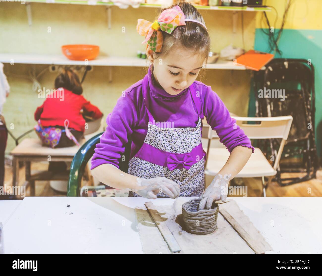 Child pottery workshop, portrait of little girl working with clay ...