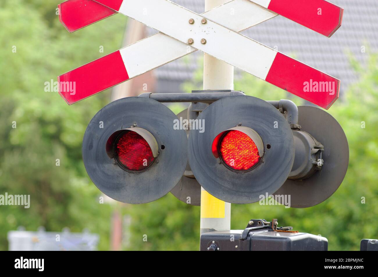 Red stop signal at a level crossing with trees in the background Stock ...