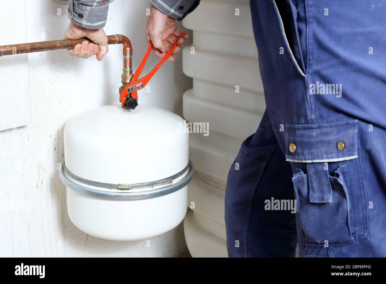 repair man is fixing a pipe in a heating room Stock Photo - Alamy