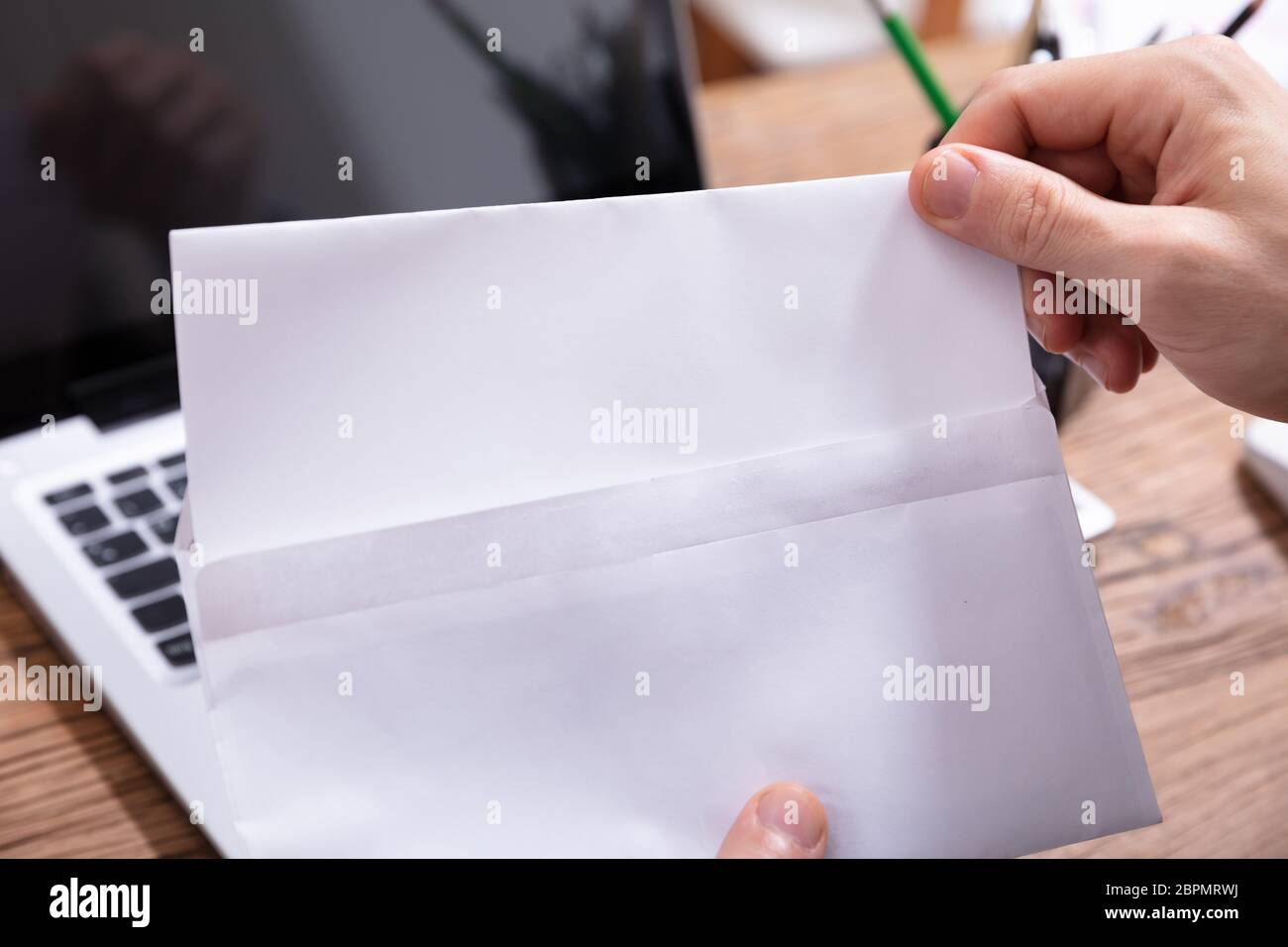 Elevated View Of A Person Removing Paper From Envelope Over Office Desk ...