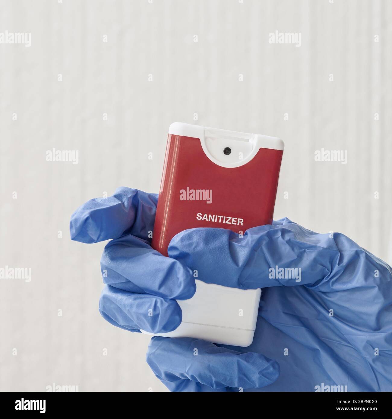 Personal hand sanitizer gel in a hand in a protective blue glove Stock ...