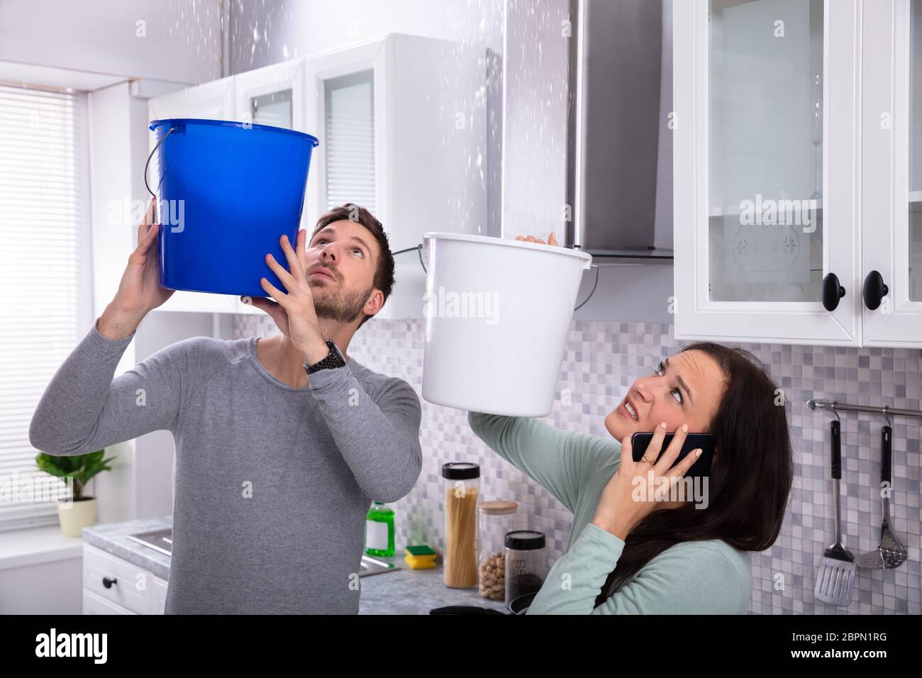 Worried Young Woman Calling Plumber On Cellphone While Man Collecting ...