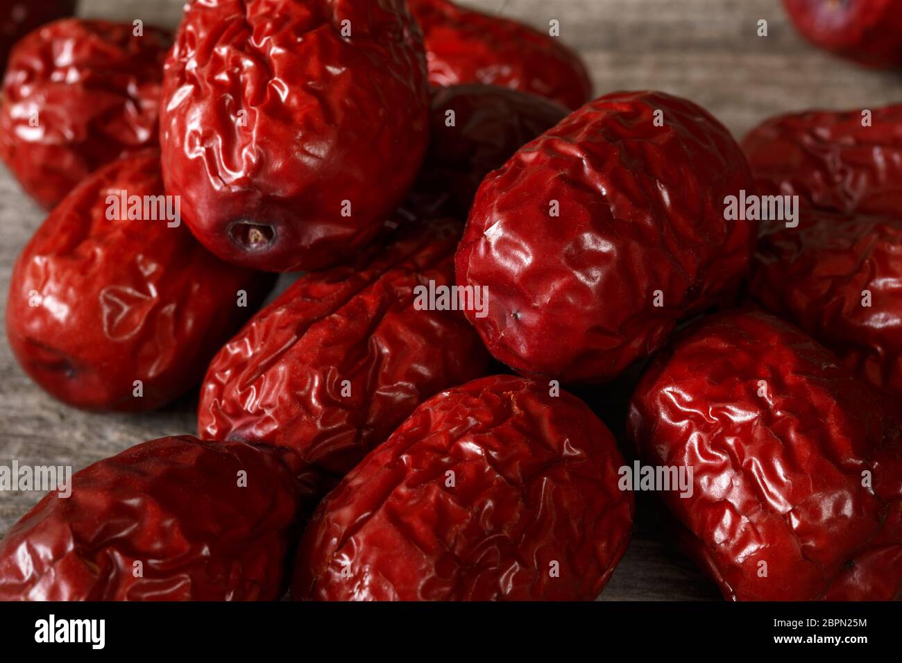A bunch of red Chinese dates on a wooden background Stock Photo - Alamy
