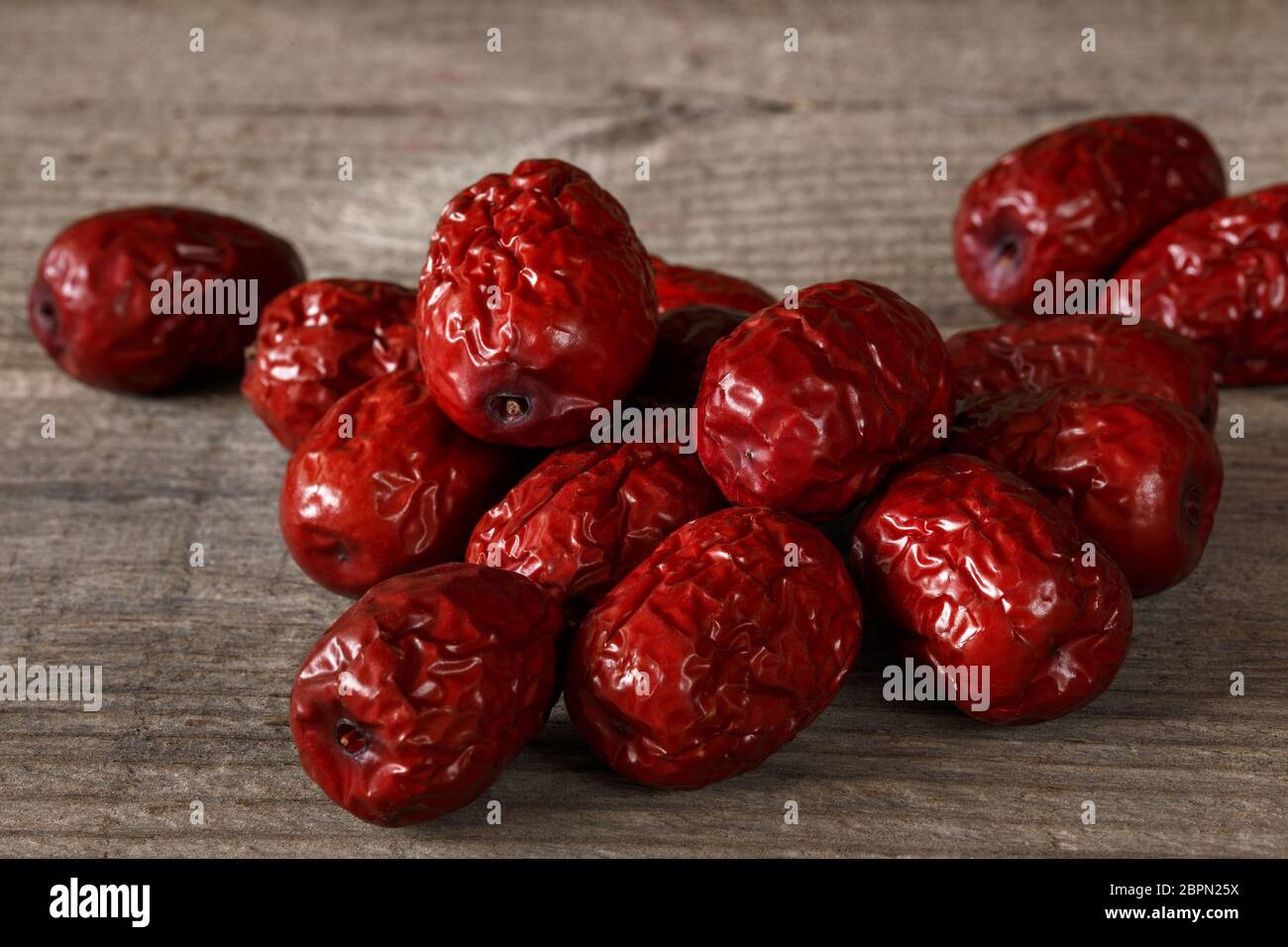 A bunch of red Chinese dates on a wooden background Stock Photo - Alamy