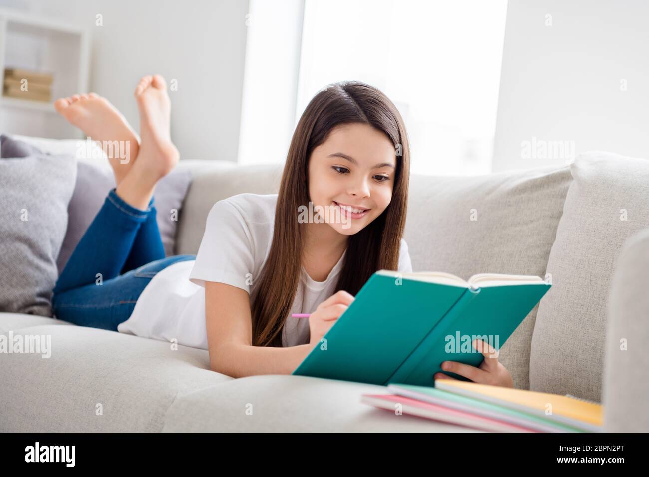 Photo of little pretty pupil school lady lying comfy sofa reading diary ...