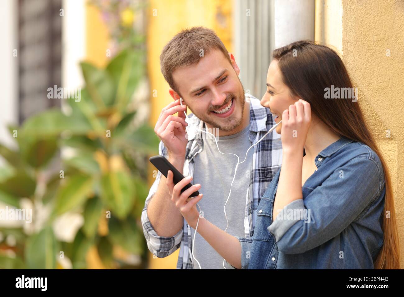 Couple sharing earbuds hi-res stock photography and images - Alamy