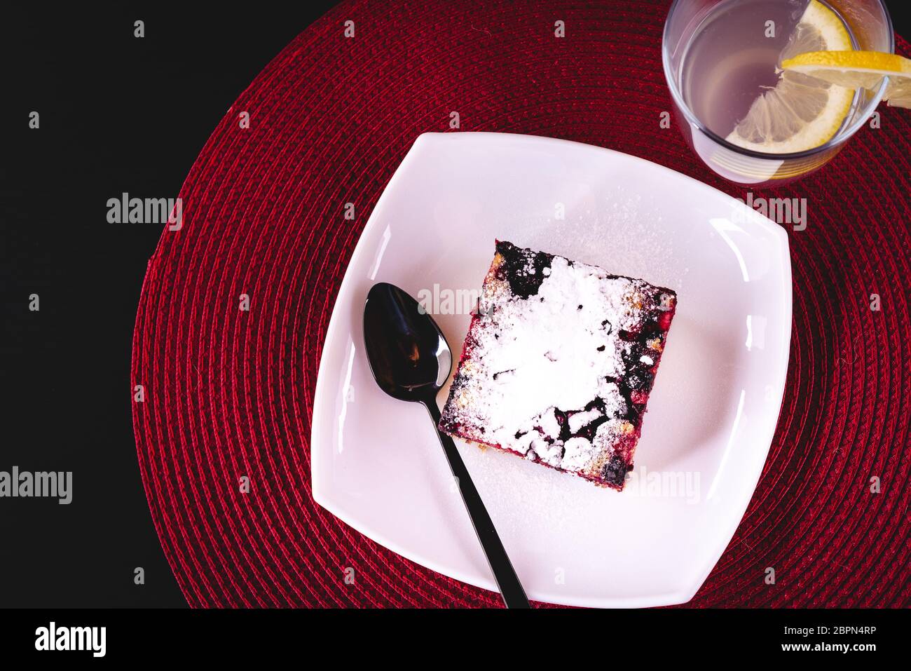 Homemade cake with forest fruit served on a plate with a glass of ...