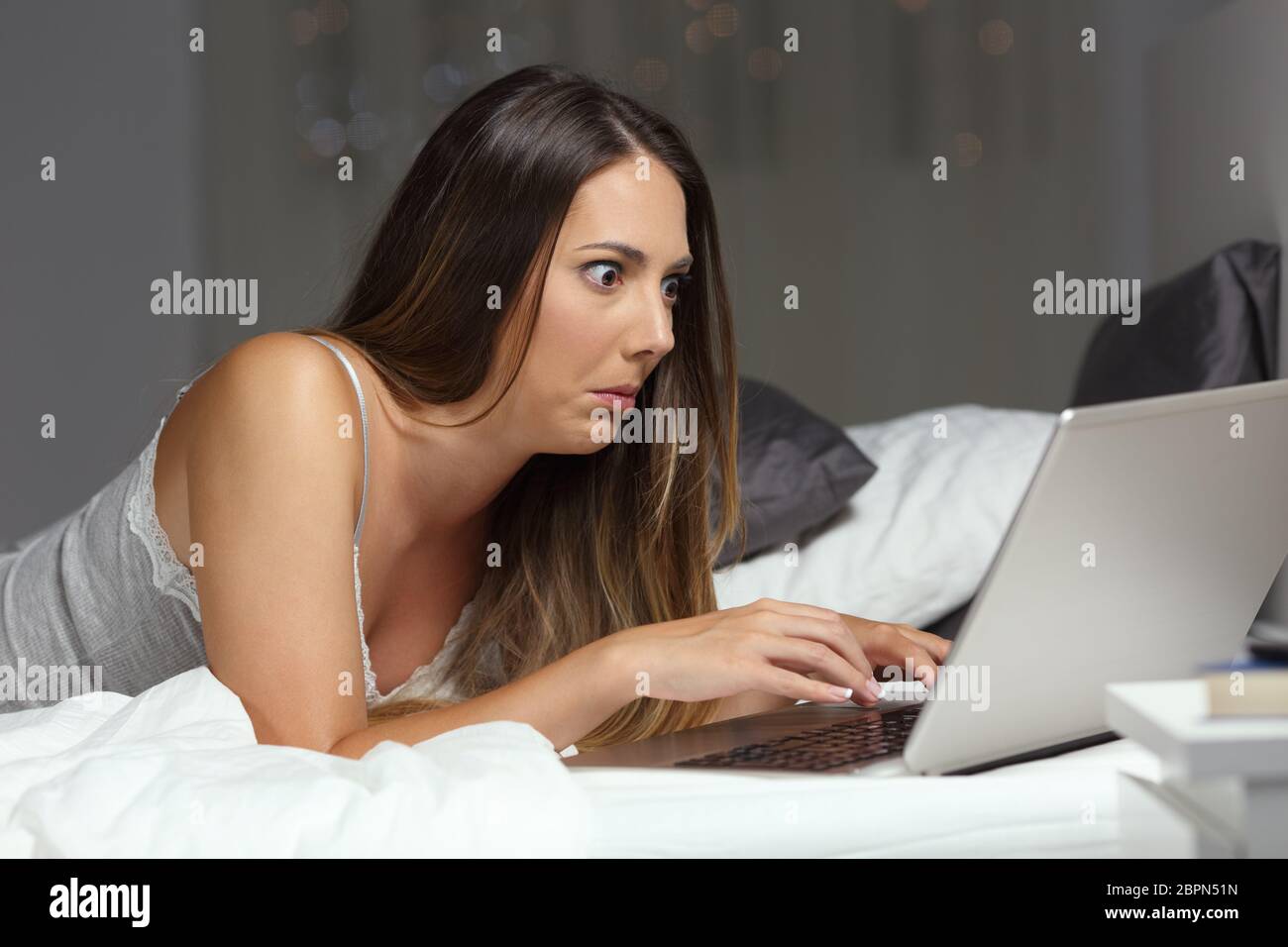 Confused woman reading a email in a laptop at home in the night Stock ...