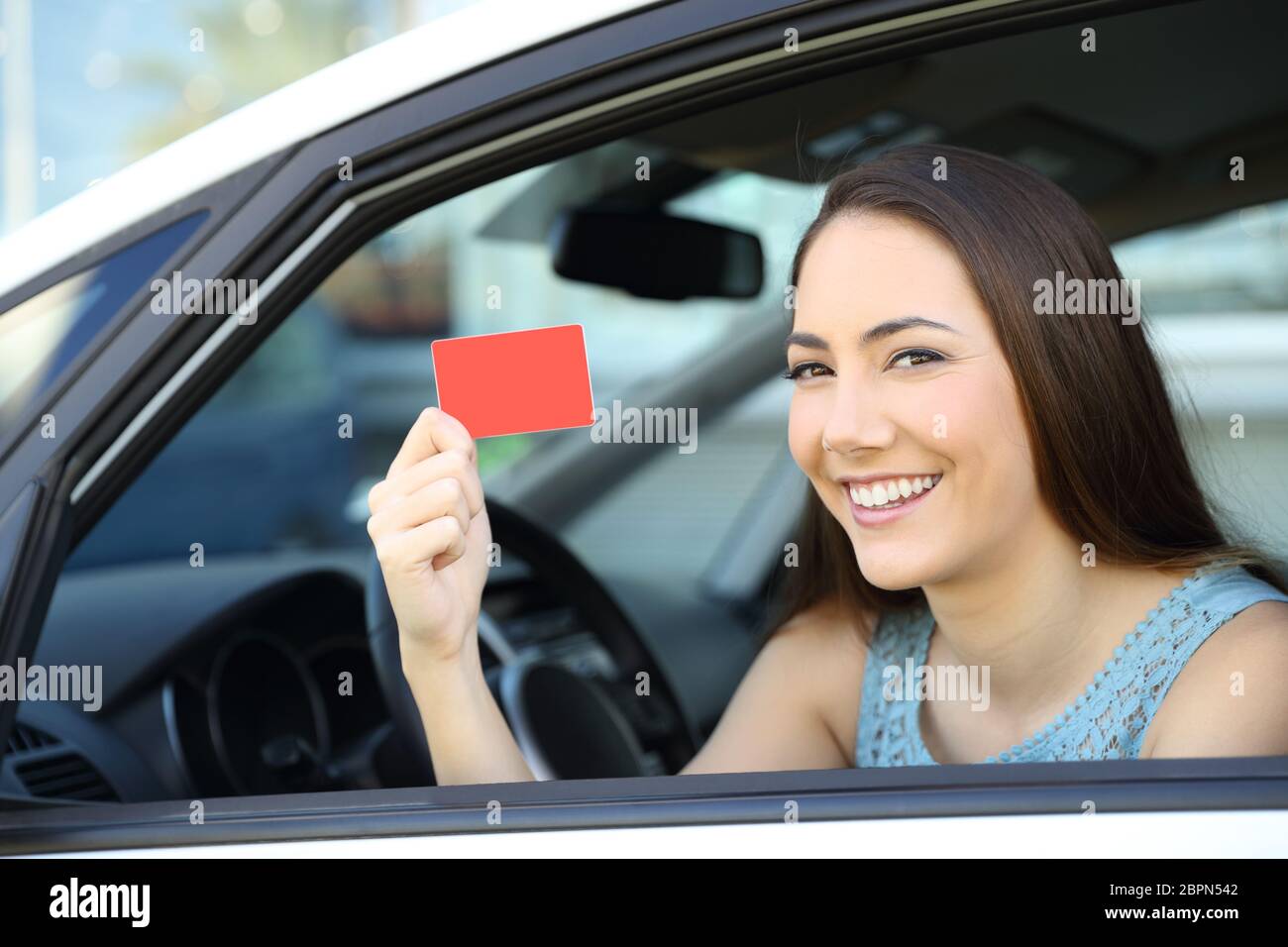 Happy driver showing a blank card looking at camera inside a car Stock ...