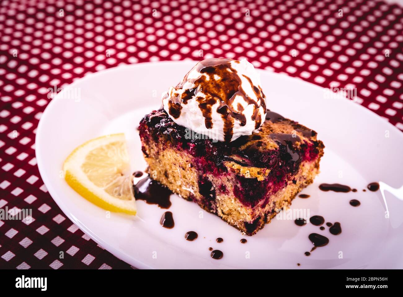 Homemade cake with forest fruit served on a plate with a glass of ...