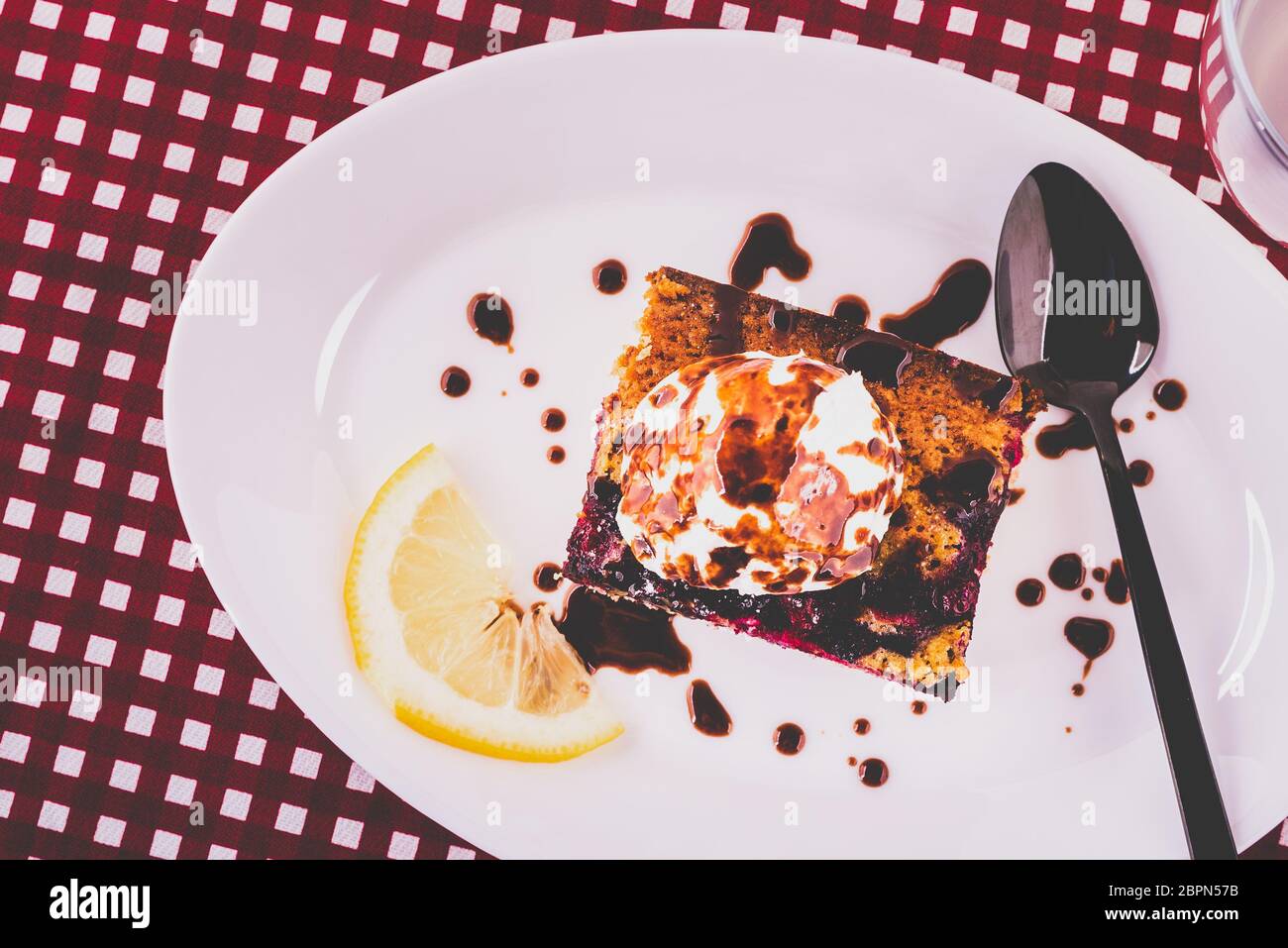 Homemade cake with forest fruit served on a plate with a glass of ...