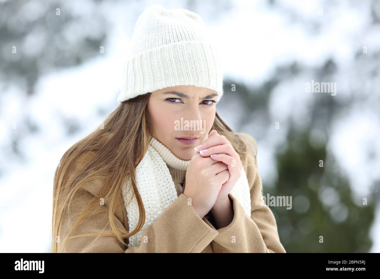Portrait of an angry woman suffering and looking at camera in a cold ...