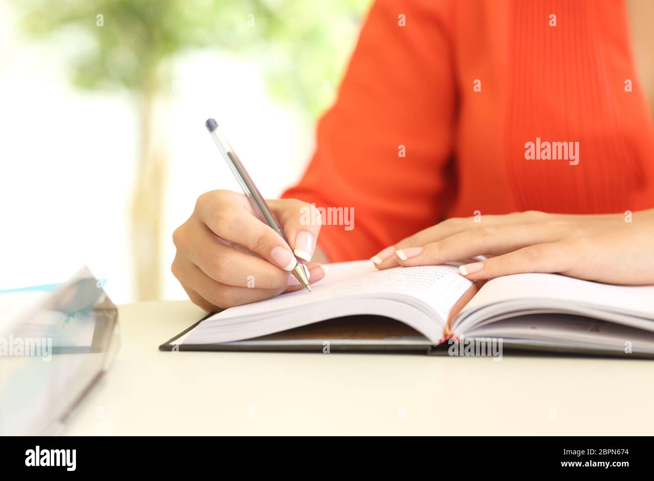Businesswoman hand writing in agenda on a desk in the office Stock ...