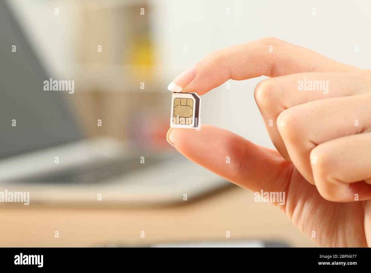 Close up of a hand holding a sim card at home Stock Photo - Alamy