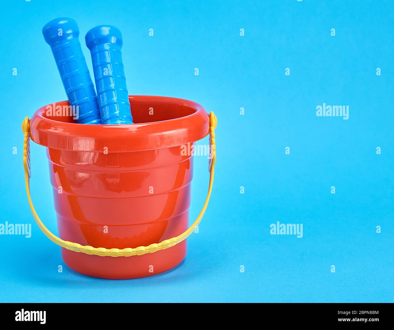 baby plastic red bucket on a blue background, copy space Stock Photo ...