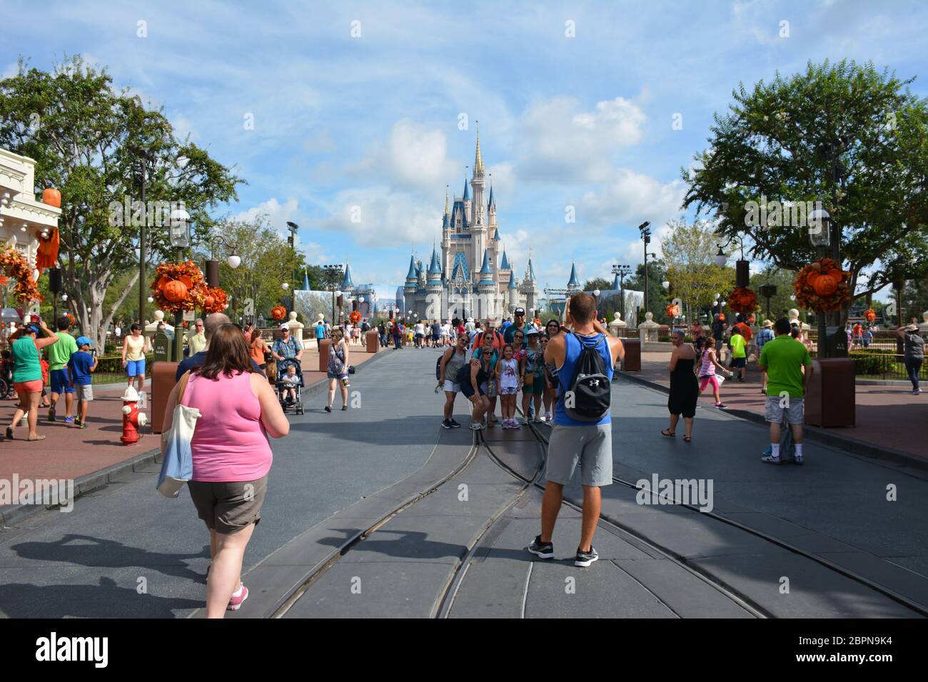 Visitors walk towards the Magic Kingdom at Walt Disney World in Florida ...
