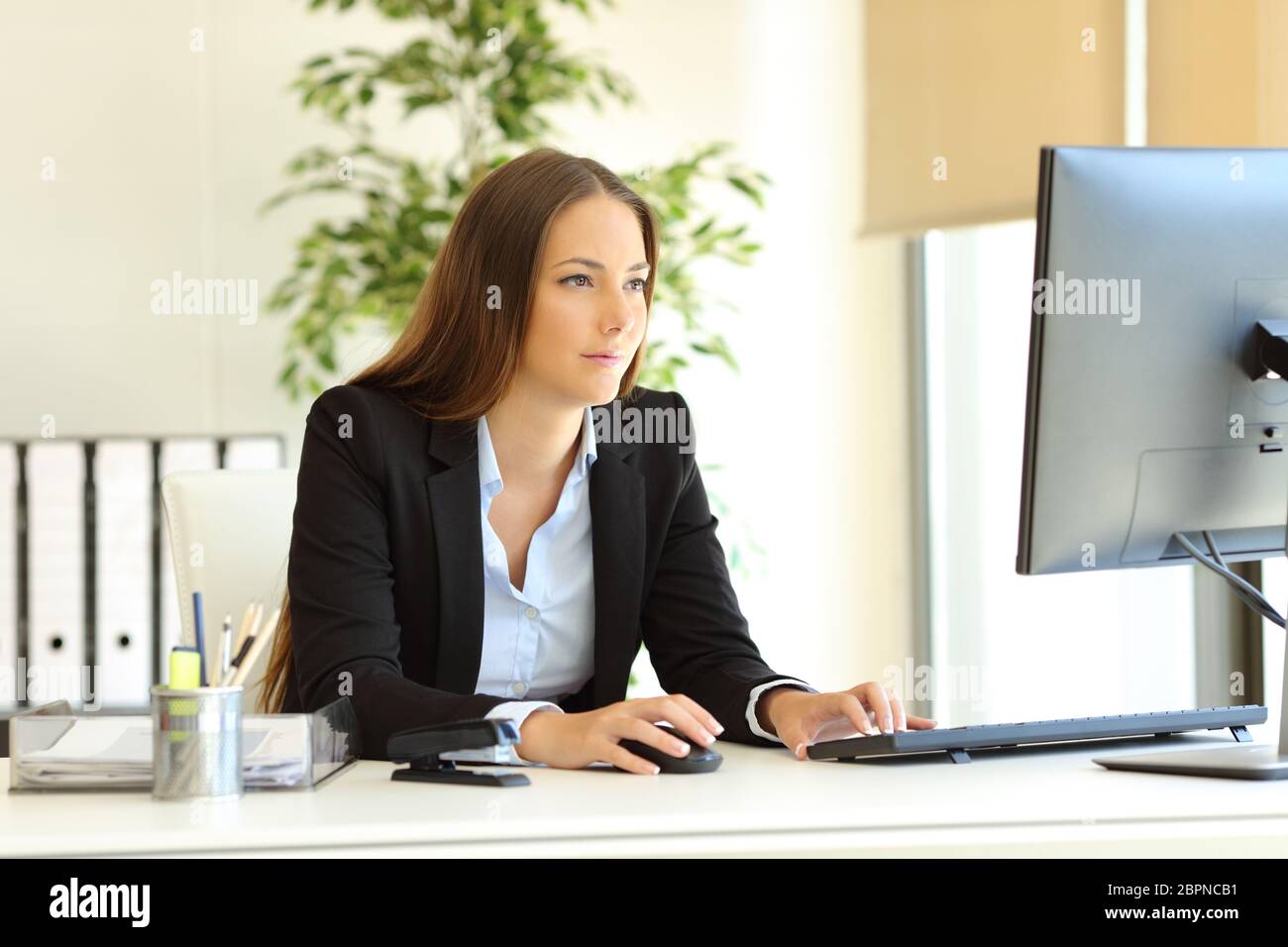 Serious office worker works using a desktop computer Stock Photo - Alamy