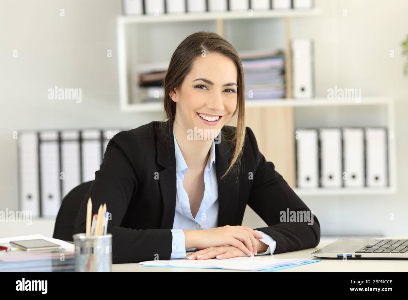 Front view portrait of a smiley office worker posing looking at camera ...