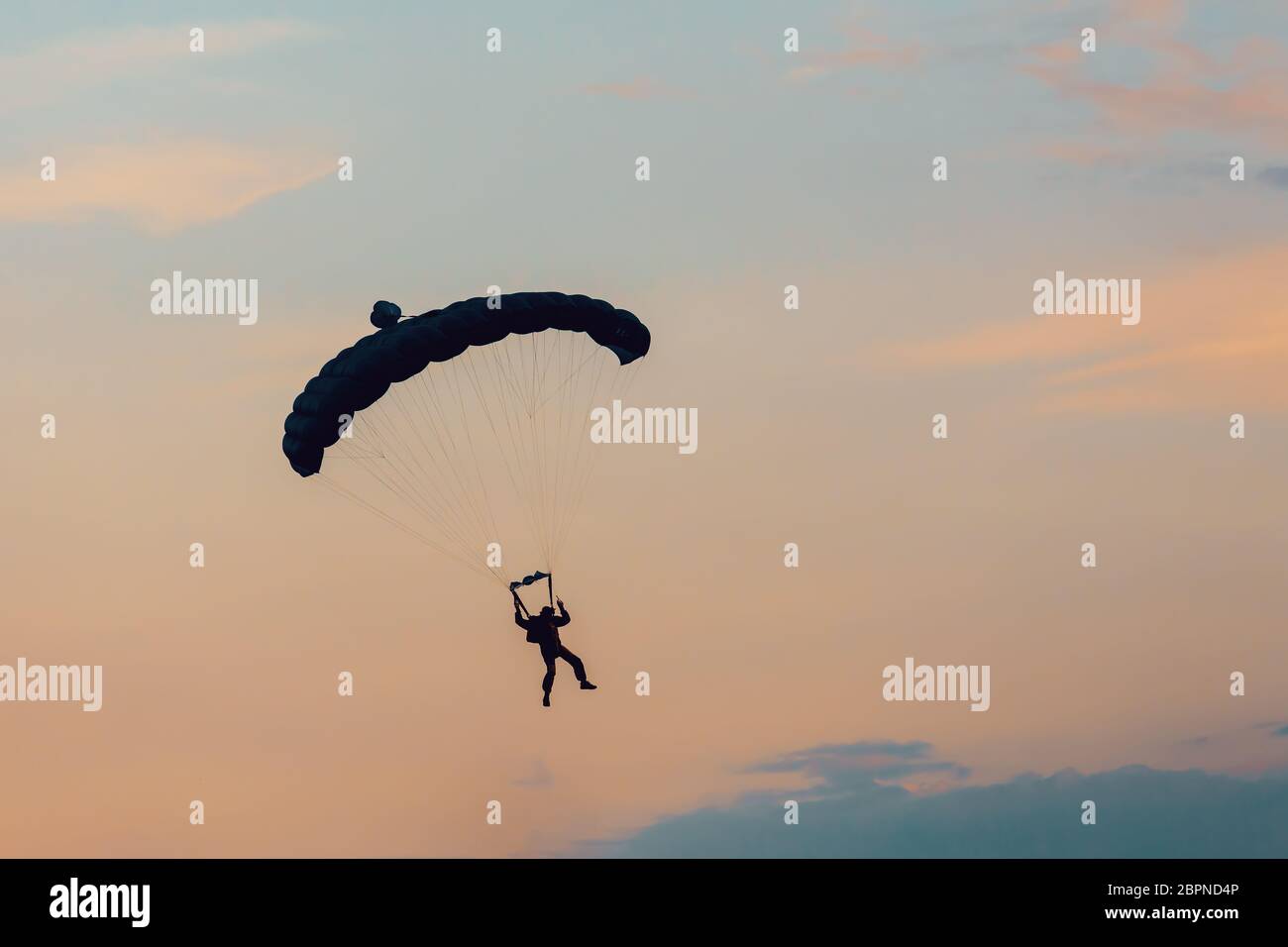 Parachutist falling from the sky in evening sunset dramatic sky ...