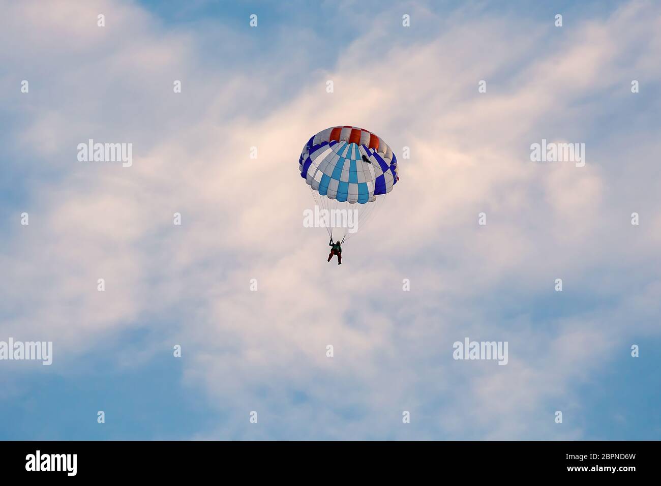 Parachutist falling from the sky in evening sunset dramatic sky ...