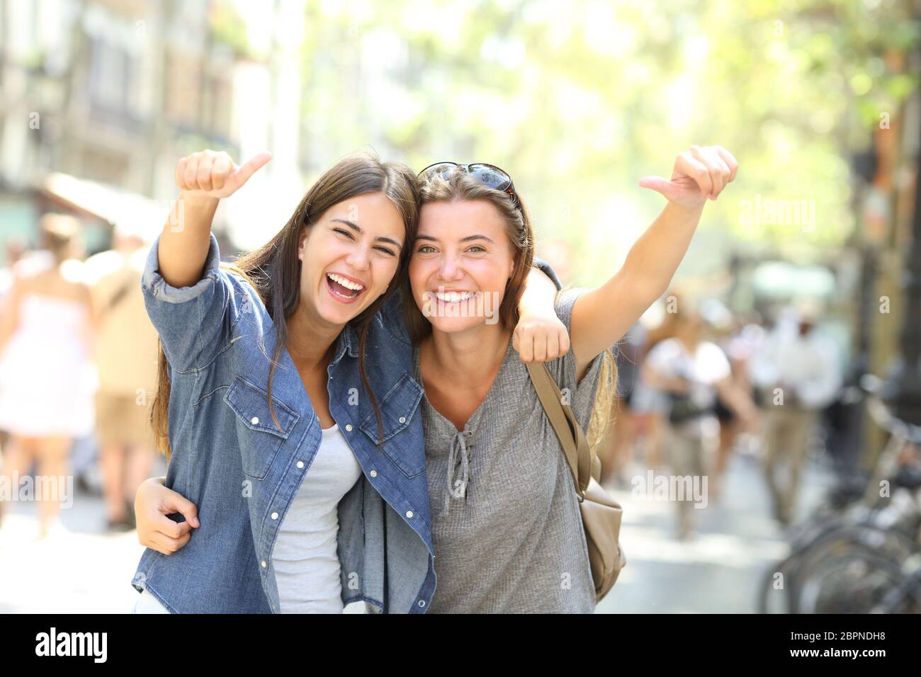 Front view portrait of two cheerful friends laughing loud looking at ...