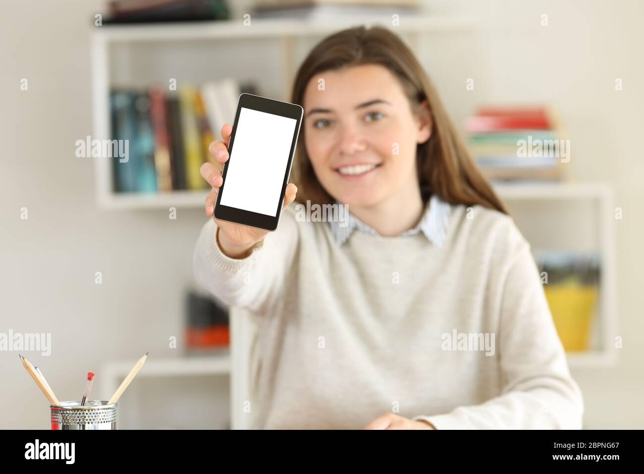 Happy student showing a smart phone screen mockup Stock Photo - Alamy