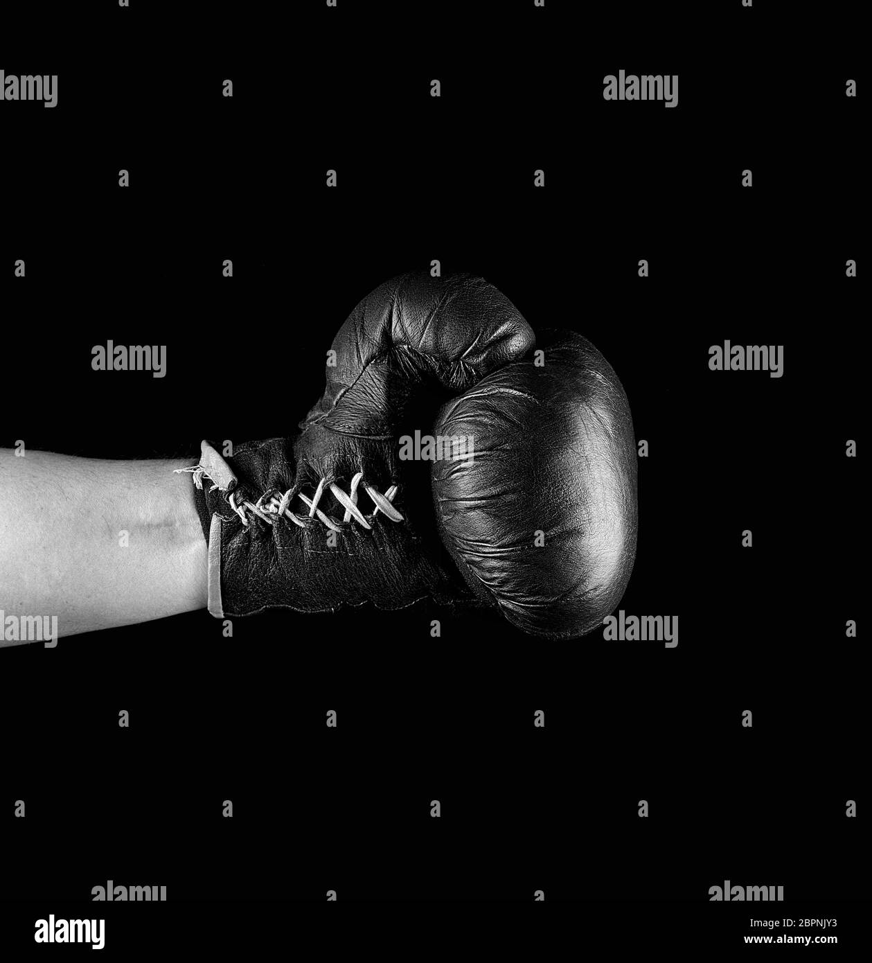 very old boxing glove dressed on man's hand, black background, black ...