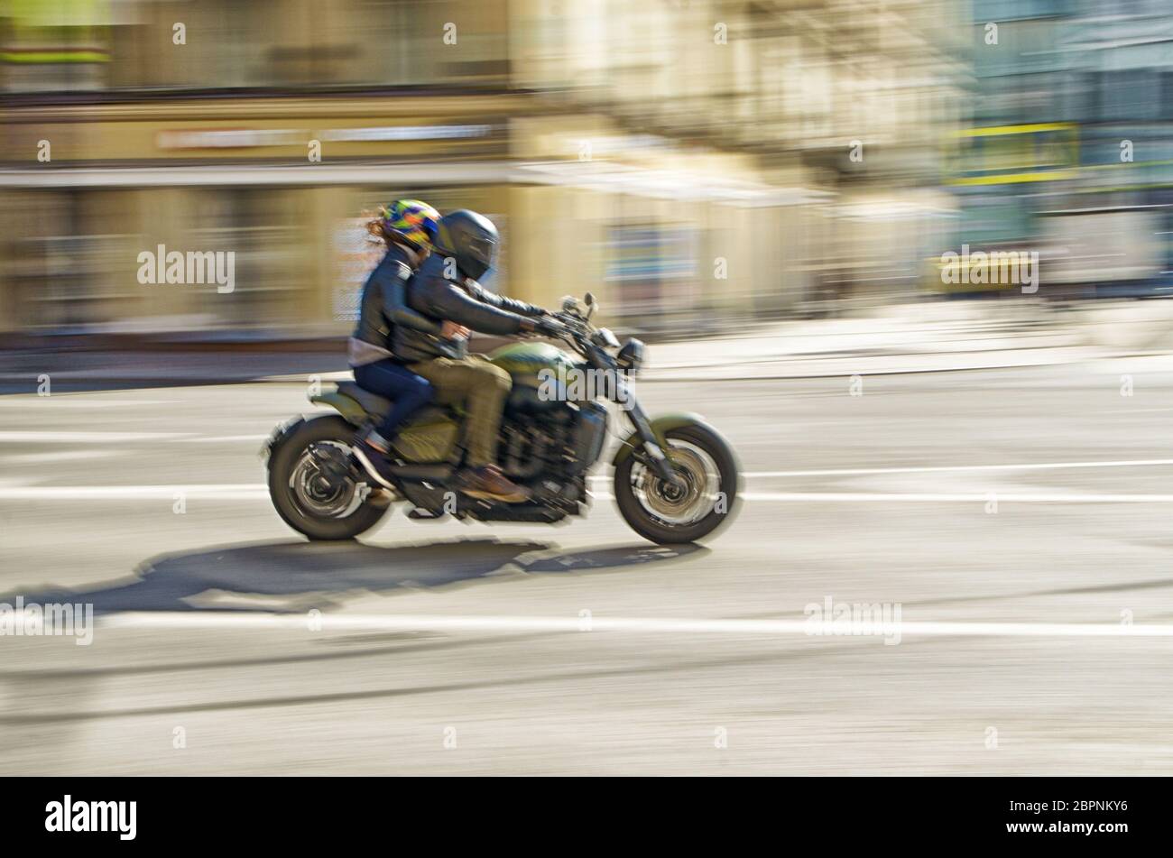 Fast motorcycle riding on a city street Stock Photo - Alamy