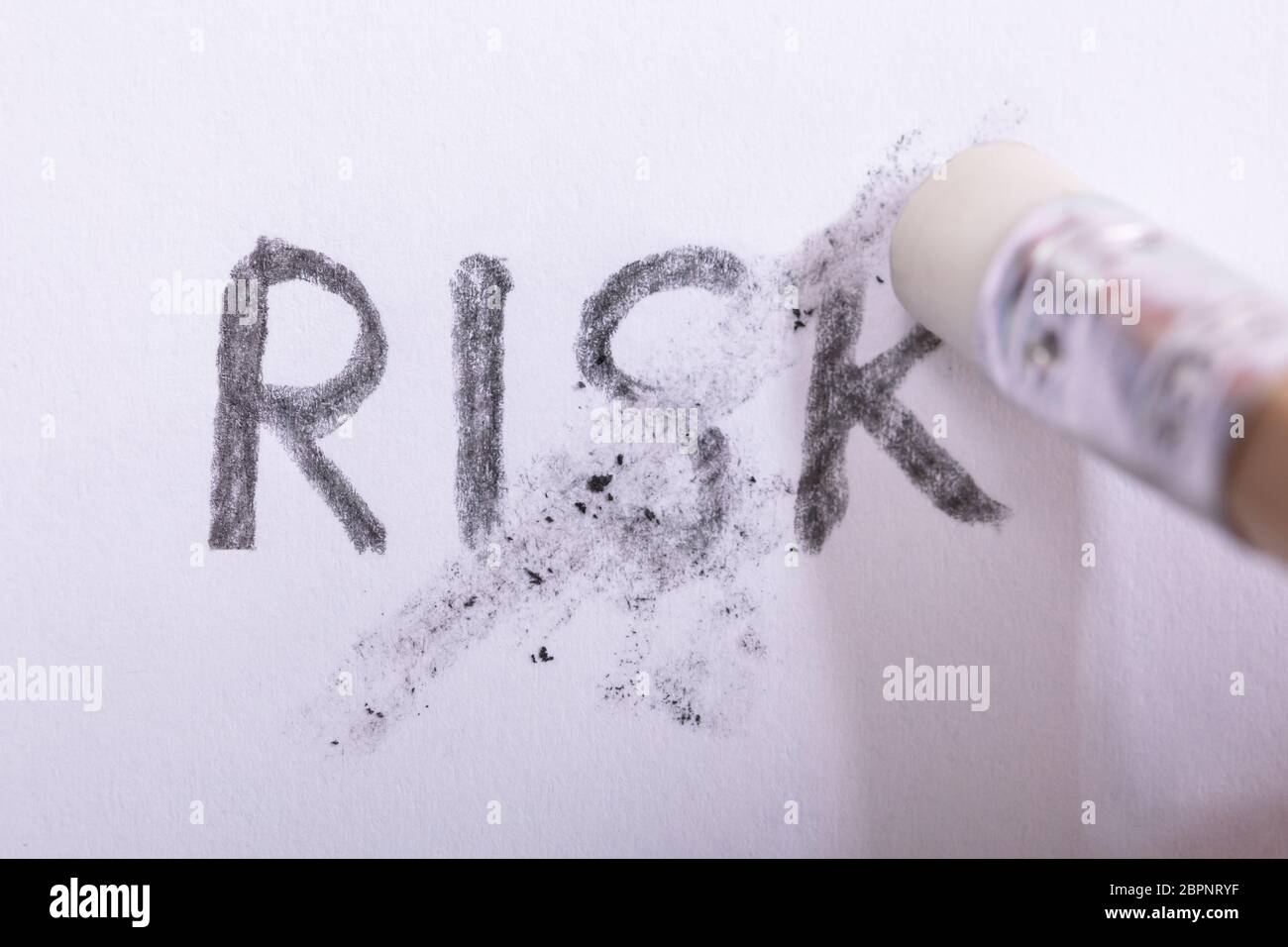 Close-up Of Pencil Eraser Erasing Risk Text On White Paper Stock Photo ...