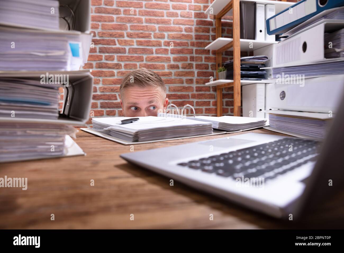 Person hiding under desk hi-res stock photography and images - Alamy