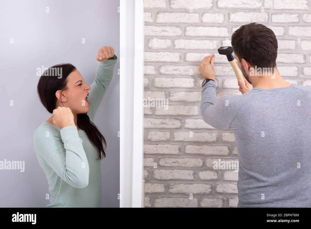 An Angry Woman Shouting Behind The Wall With The Neighbor Man Hitting ...