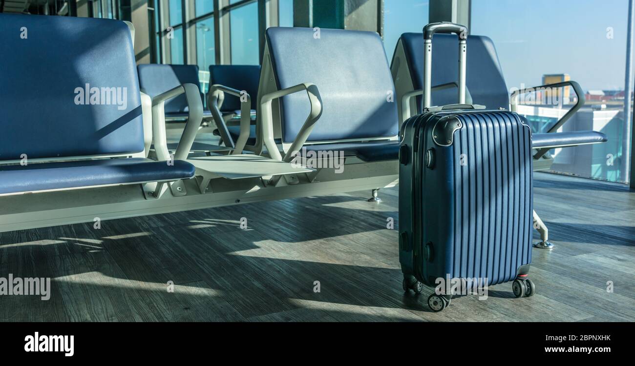 Small plastic travel suitcase in the airport hall Stock Photo - Alamy