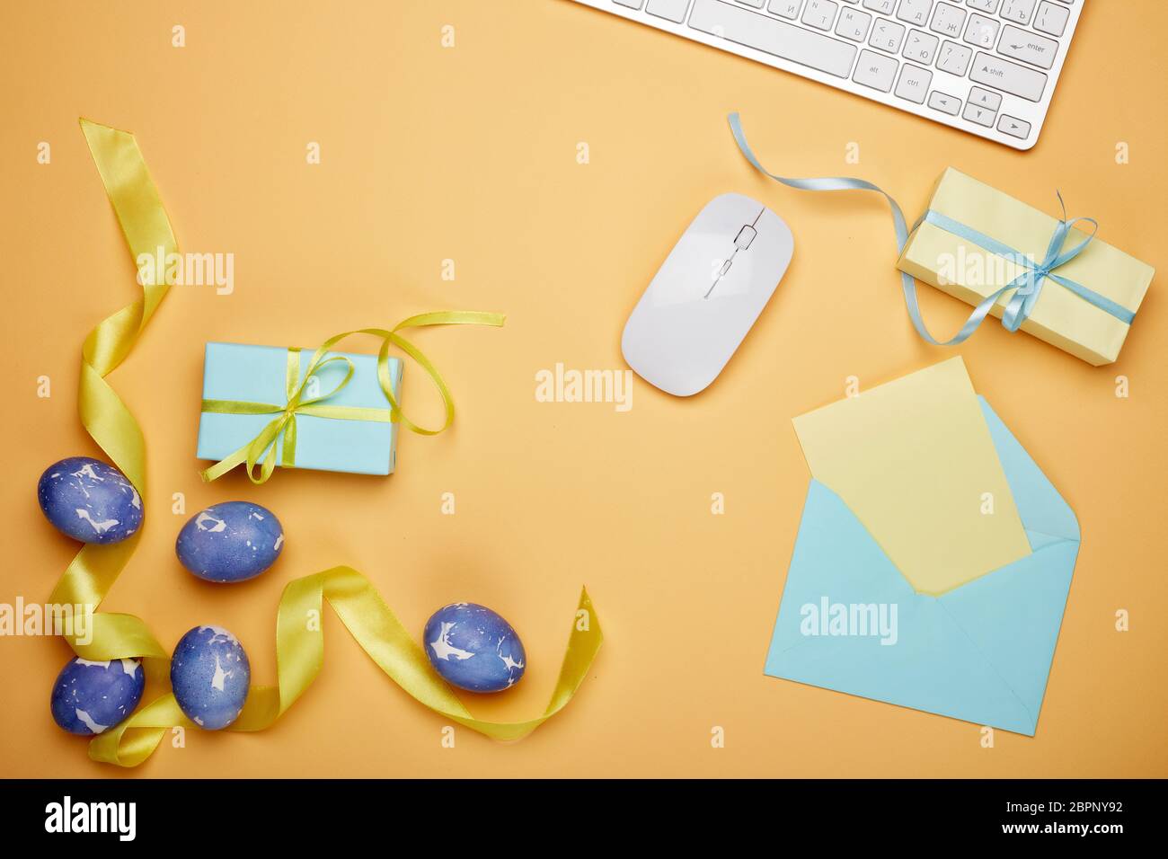 Colored easter eggs, gift box, computer keyboard and mouse, blank sheet ...