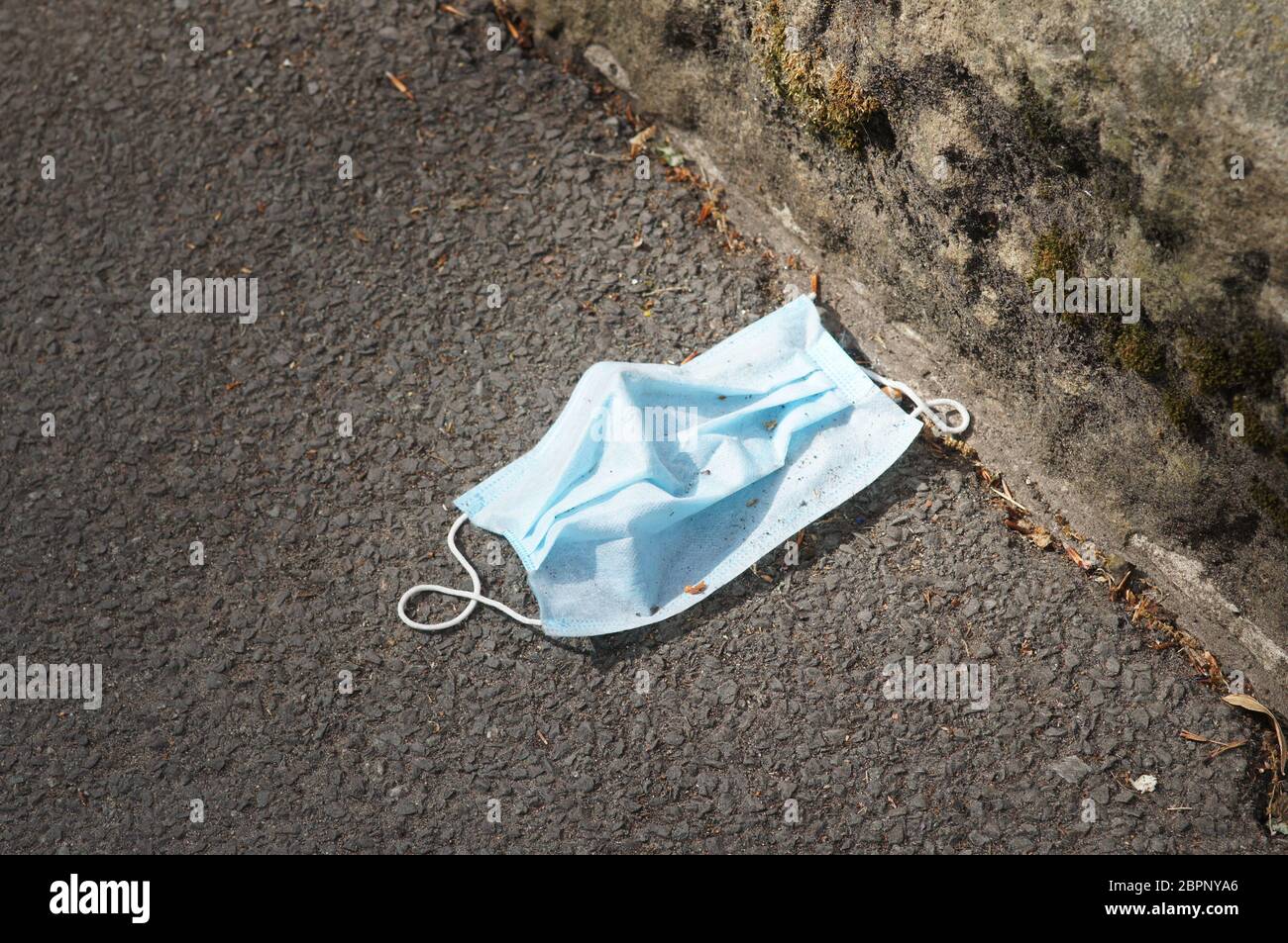 PPE mask discarded on ground Stock Photo - Alamy