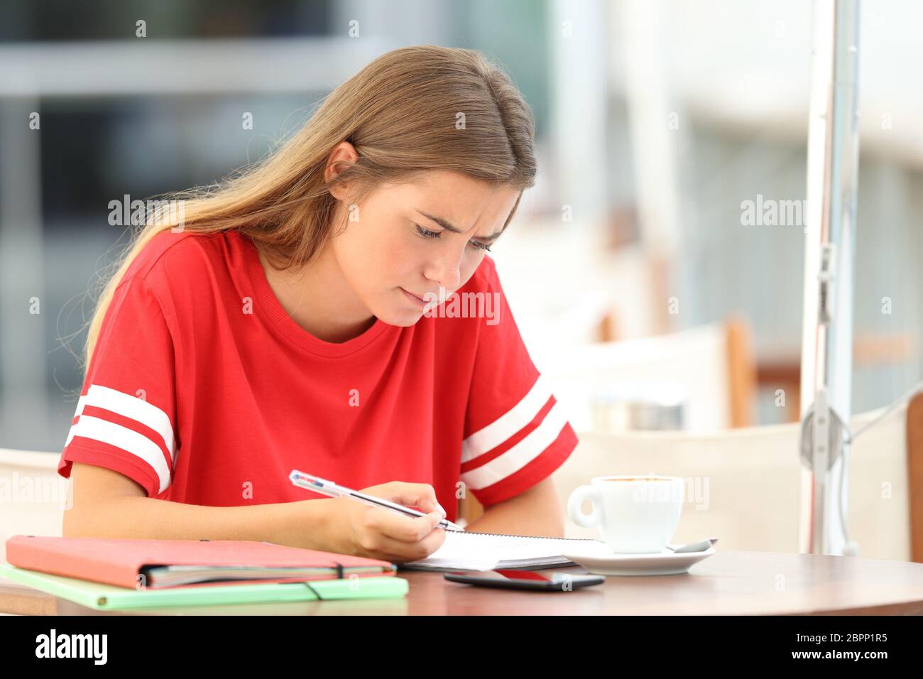 Single confused student studying reading notes sitting in a bar Stock ...
