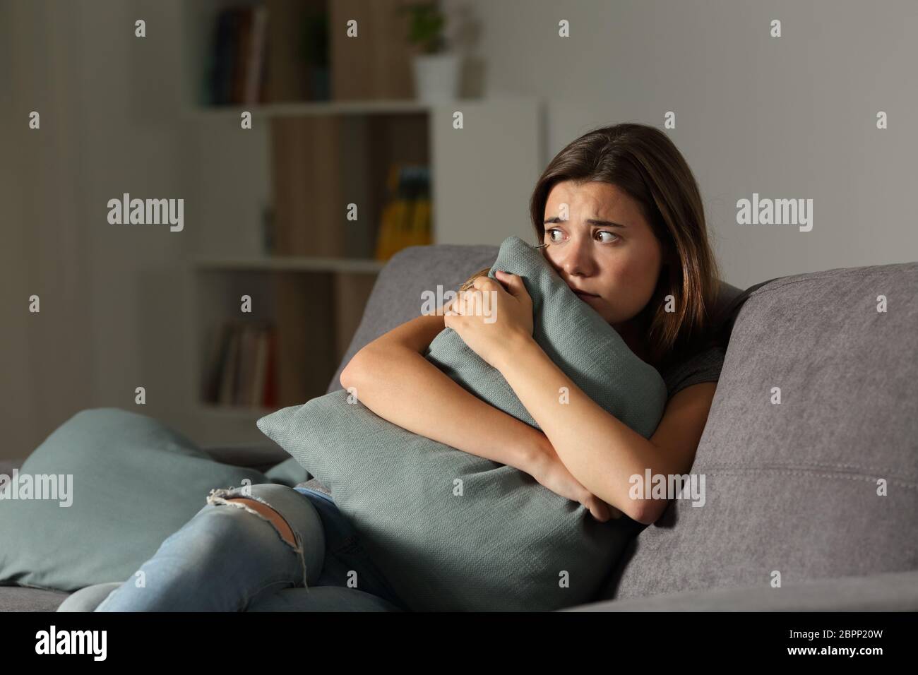 Girl sitting on sofa afraid hi-res stock photography and images - Alamy
