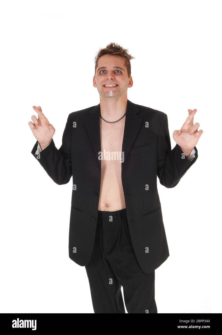 A smiling young man in a dark jacket but without a shirt standing with ...